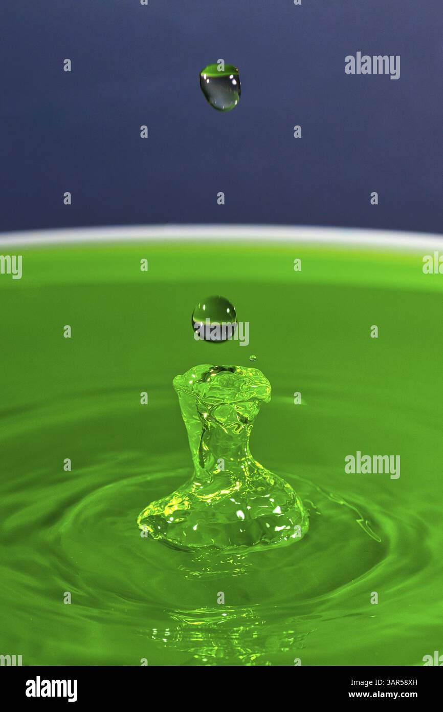 A green tone water drop forms an artistic figure on the surface, water ...