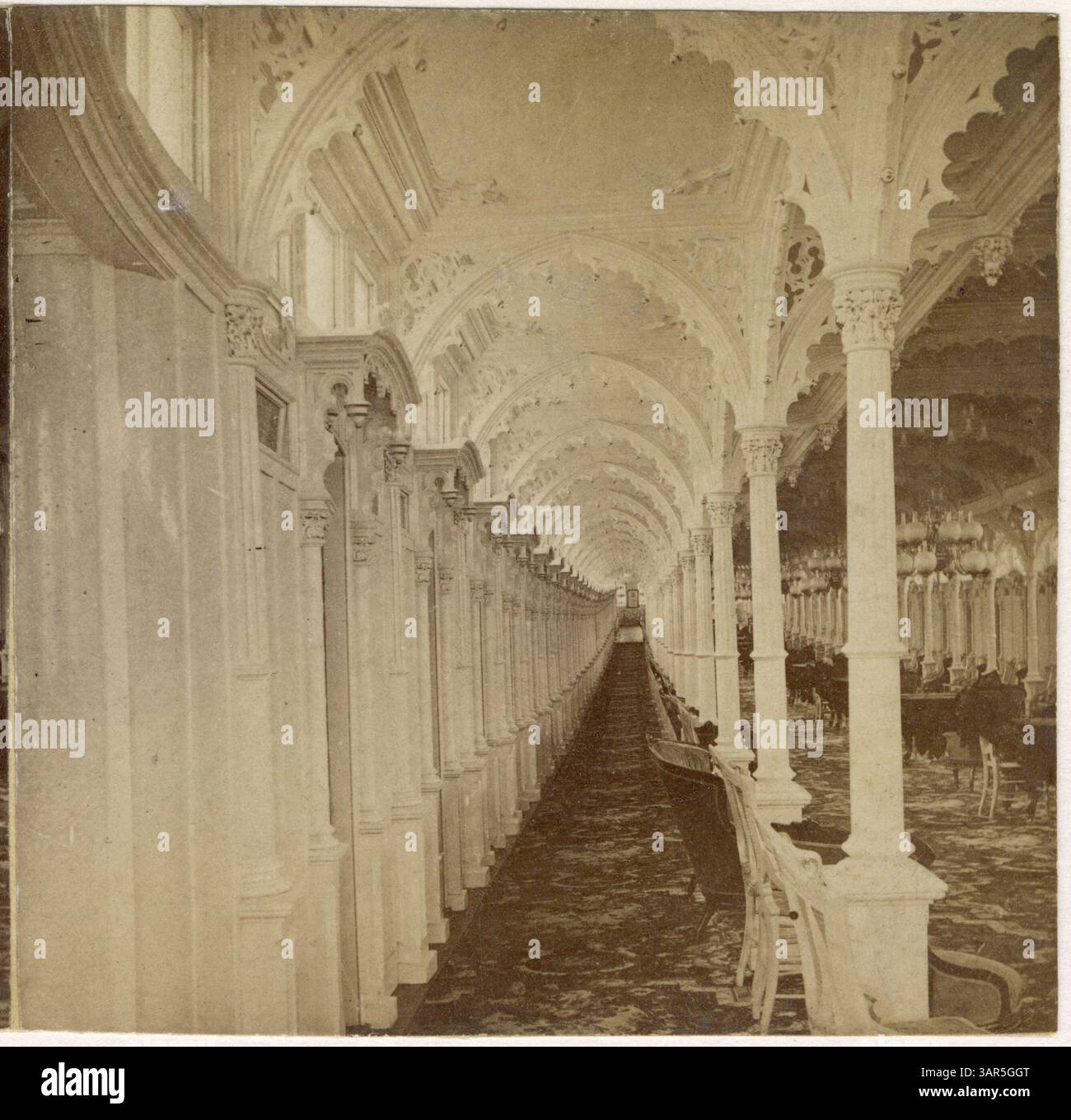 A black-and-white stereograph photograph depicts an aisle in the cabin ...
