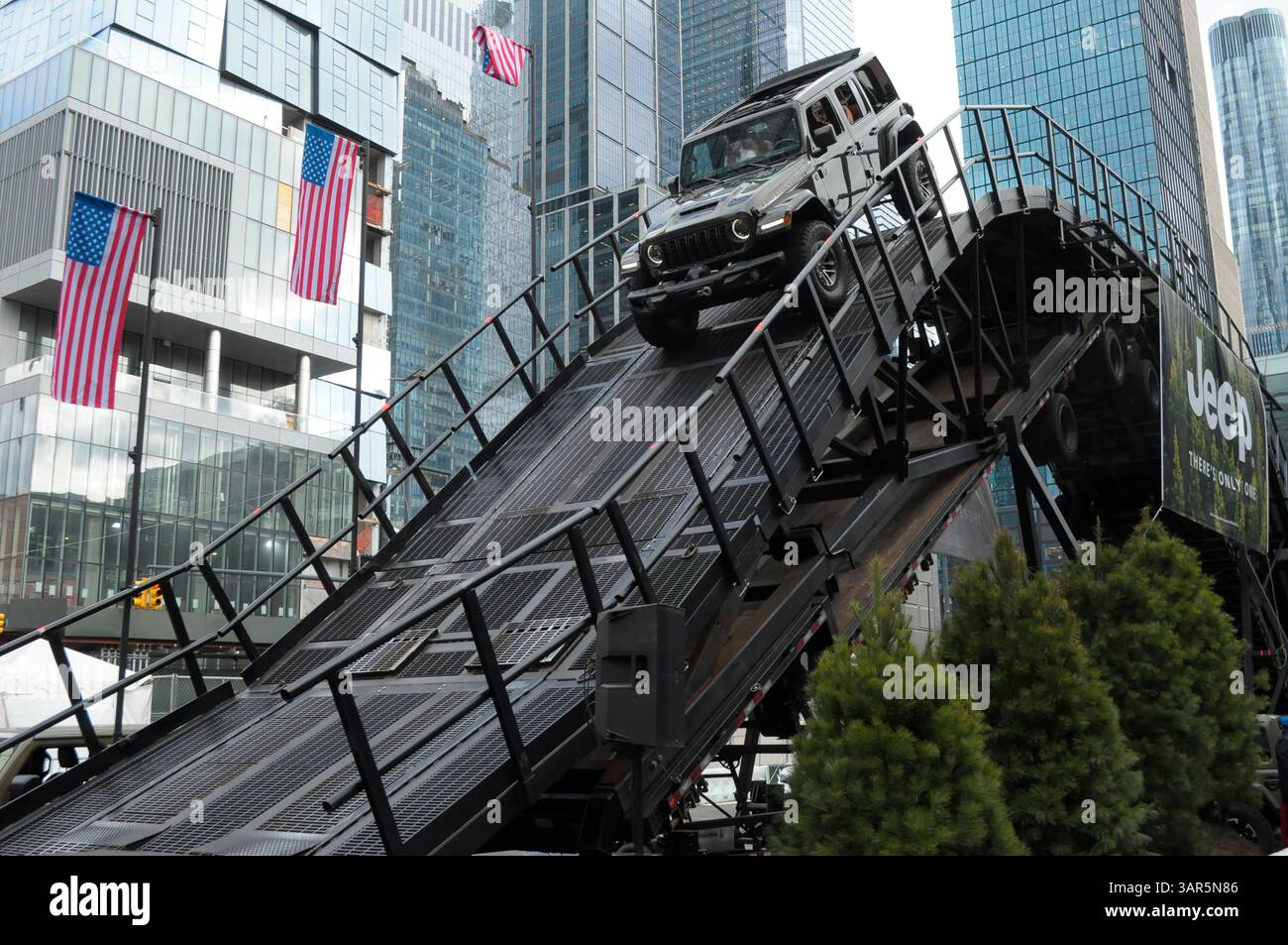 A person drives a Jeep Wrangler Rubicon down a ramp at an exhibition on ...