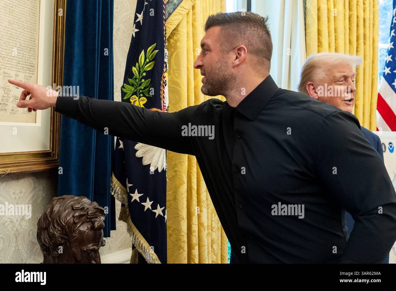 Tim Tebow pointing out a signature on a copy of the Declaration of ...