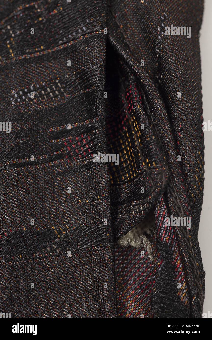 An abstractly designed tie in black, red, yellow, and blue that is ...