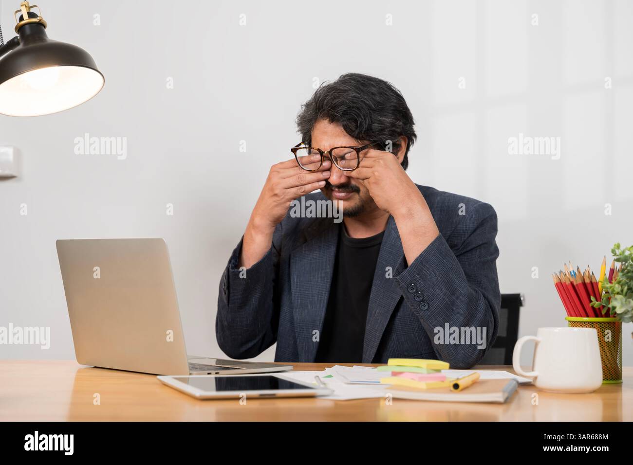 Young man with eye pain, headache, wearing glasses, abnormal vision ...