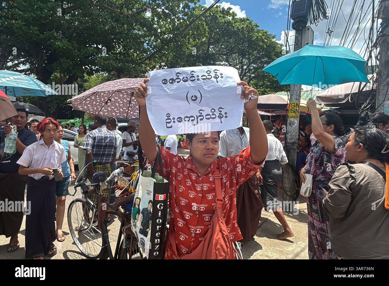 A person holds a sign of name as family members and colleagues wait to ...