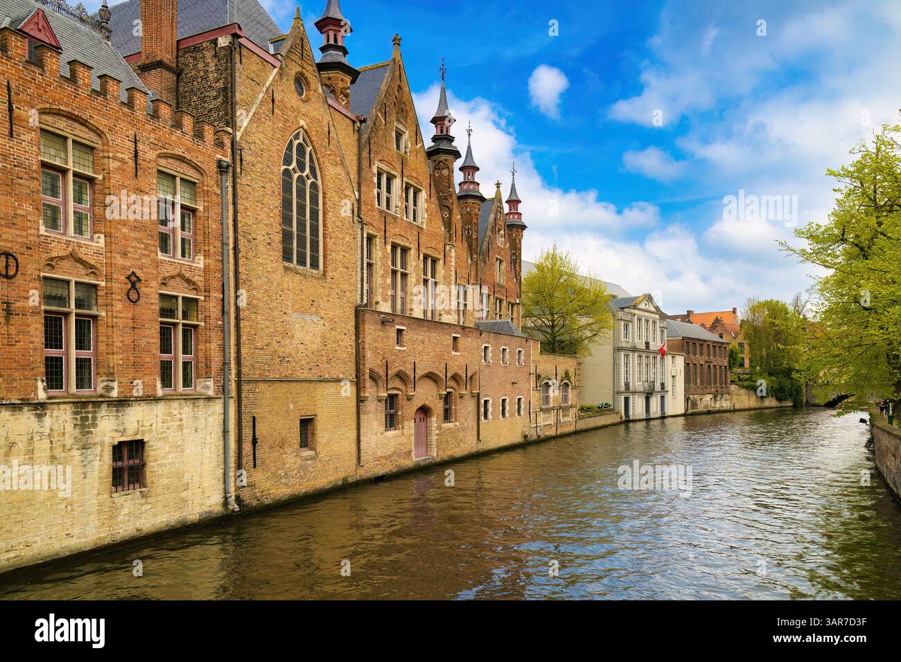 Ornate historic Gothic building with turrets alongside a canal in ...