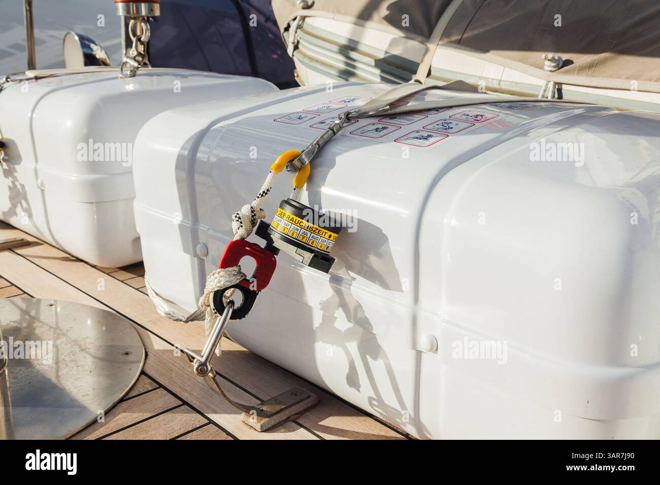 Life raft in capsules are fixed on the teak deck of the yacht in close ...