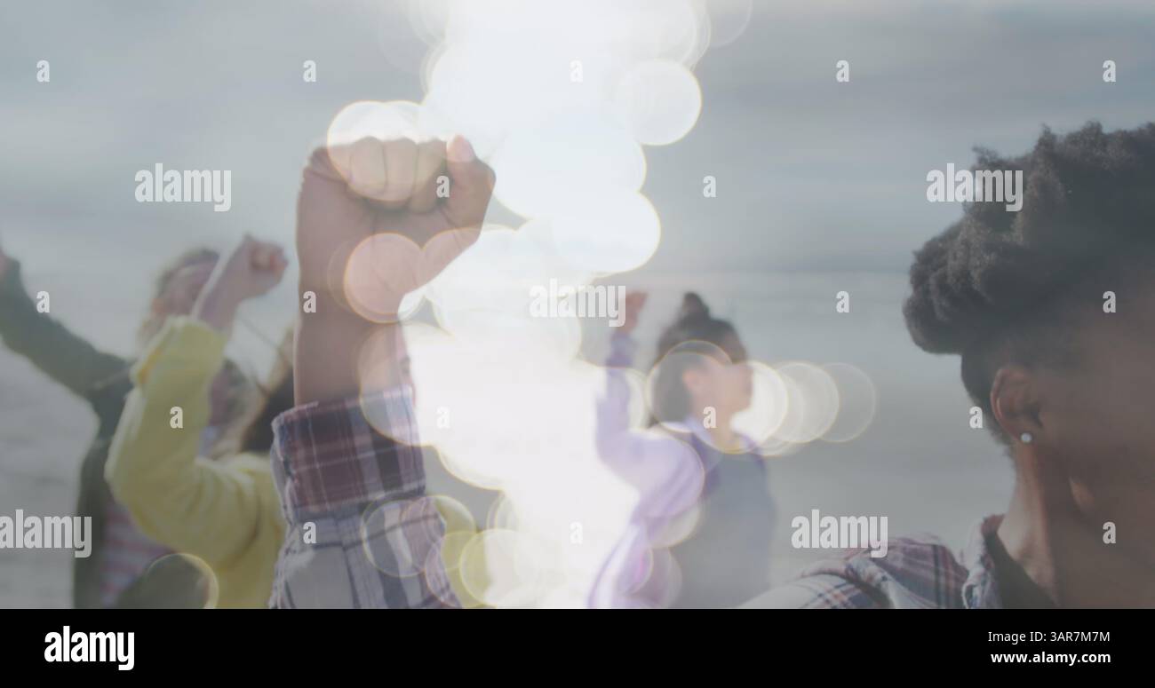 Image of diverse women raising hands over light spots Stock Photo - Alamy
