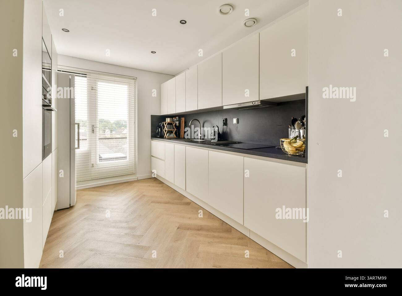A sleek, modern kitchen featuring white cabinetry, minimalist design, and a stylish layout that ...