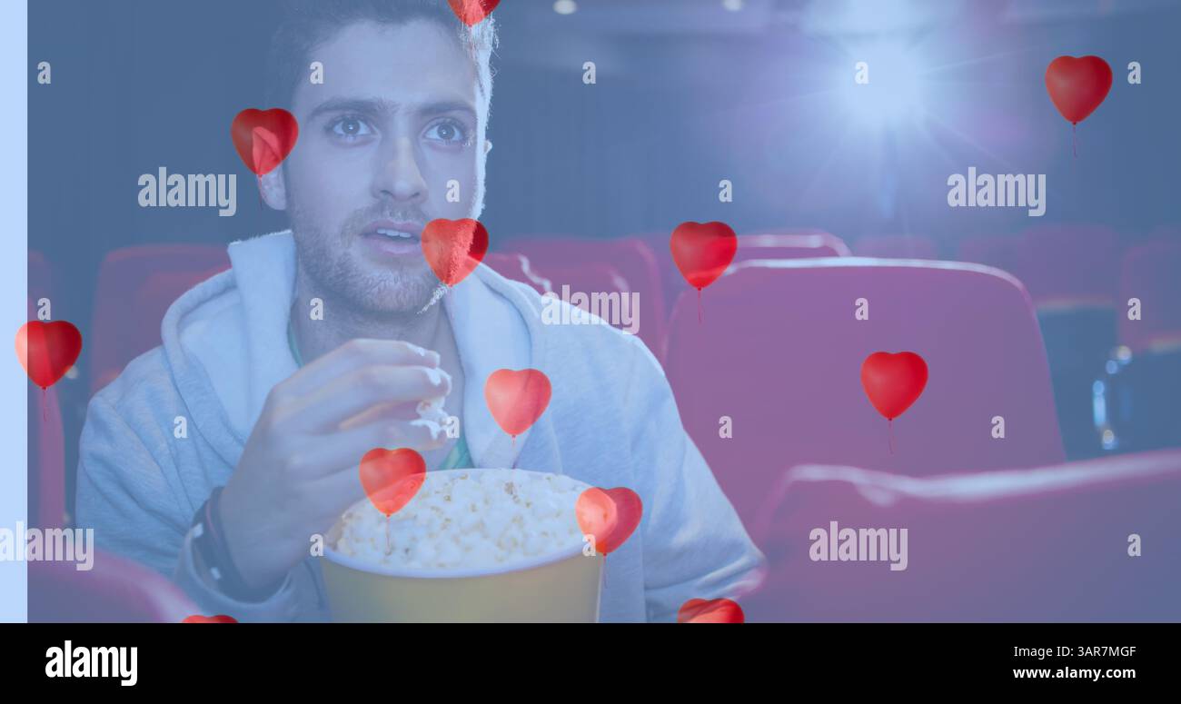 Image of heart icons over caucasian man eating popcorn in cinema Stock ...