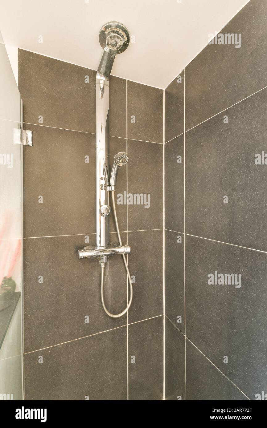 Sleek shower fixture mounted on a tiled wall, showcasing a contemporary ...