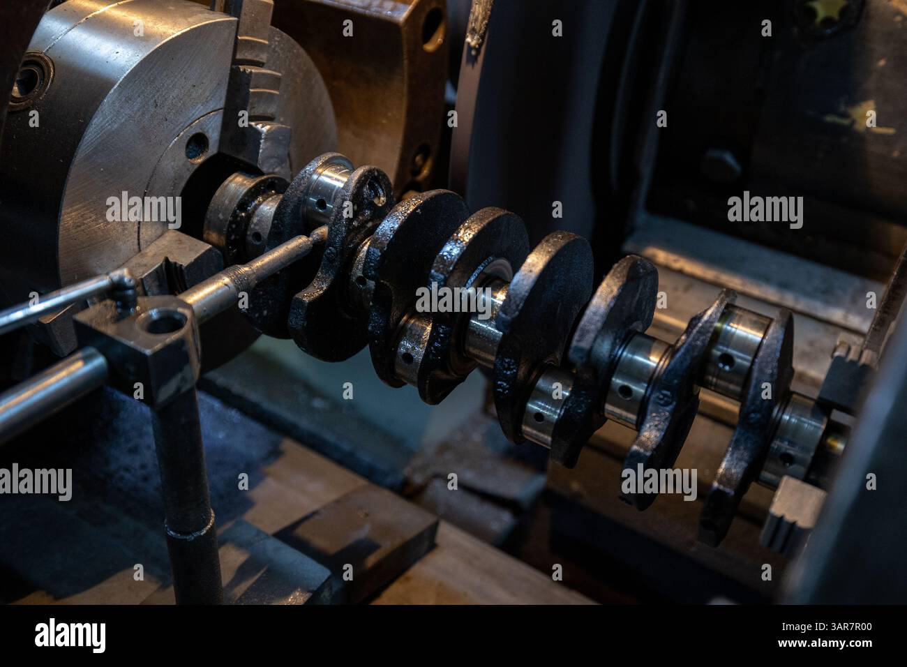 A crankshaft is securely mounted in a grinding machine within a ...