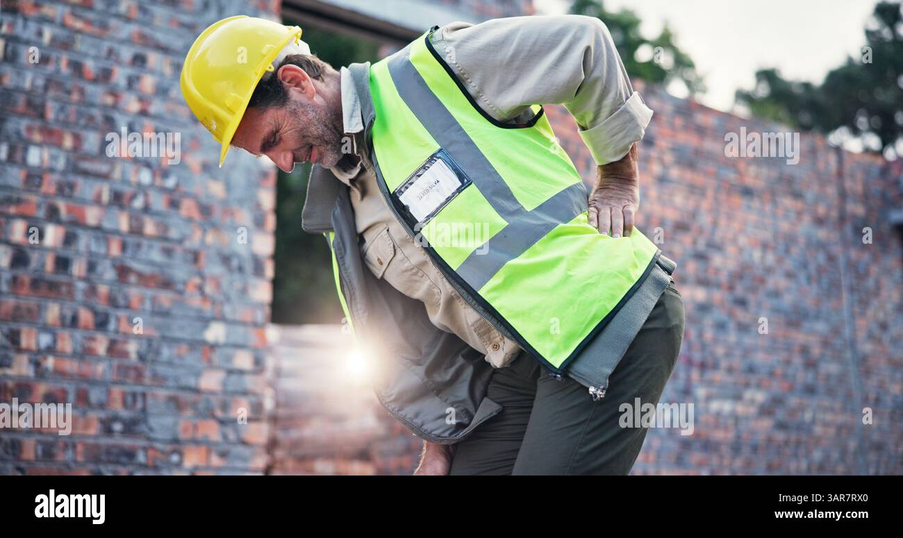 Man, construction worker and back pain with injury, work site accident ...