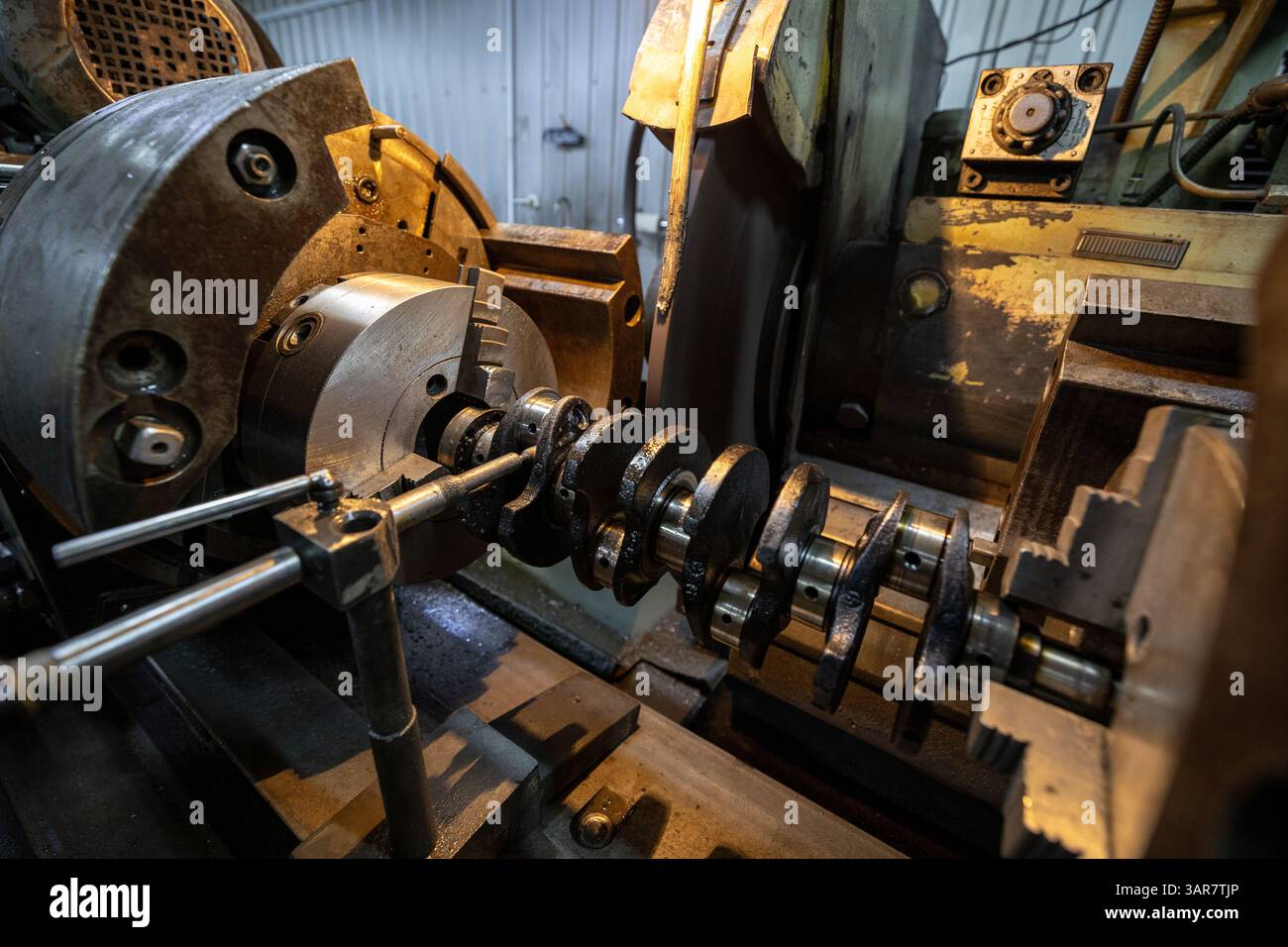 A crankshaft is securely mounted in a grinding machine within a ...