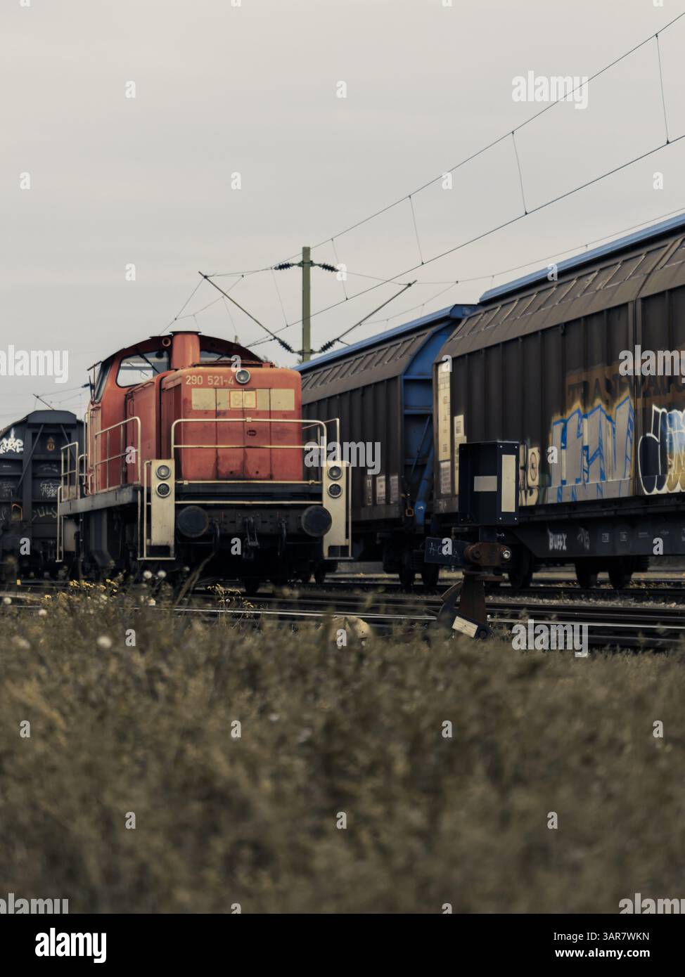 Red diesel locomotive among freight cars Stock Photo - Alamy
