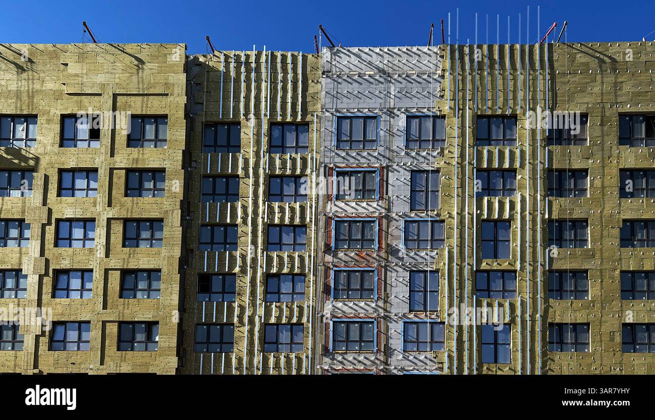 Multi-story building under renovation, showcasing exposed insulation ...