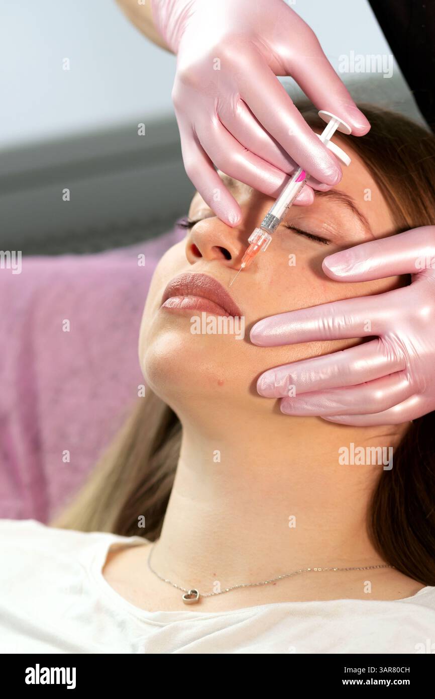 Esthetician administers hyaluronic lip filler with precision. Aesthetic ...