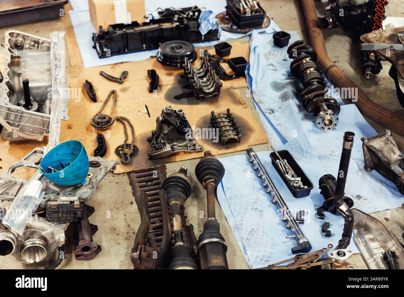 Disassembled engine components spread across workshop floor showing ...