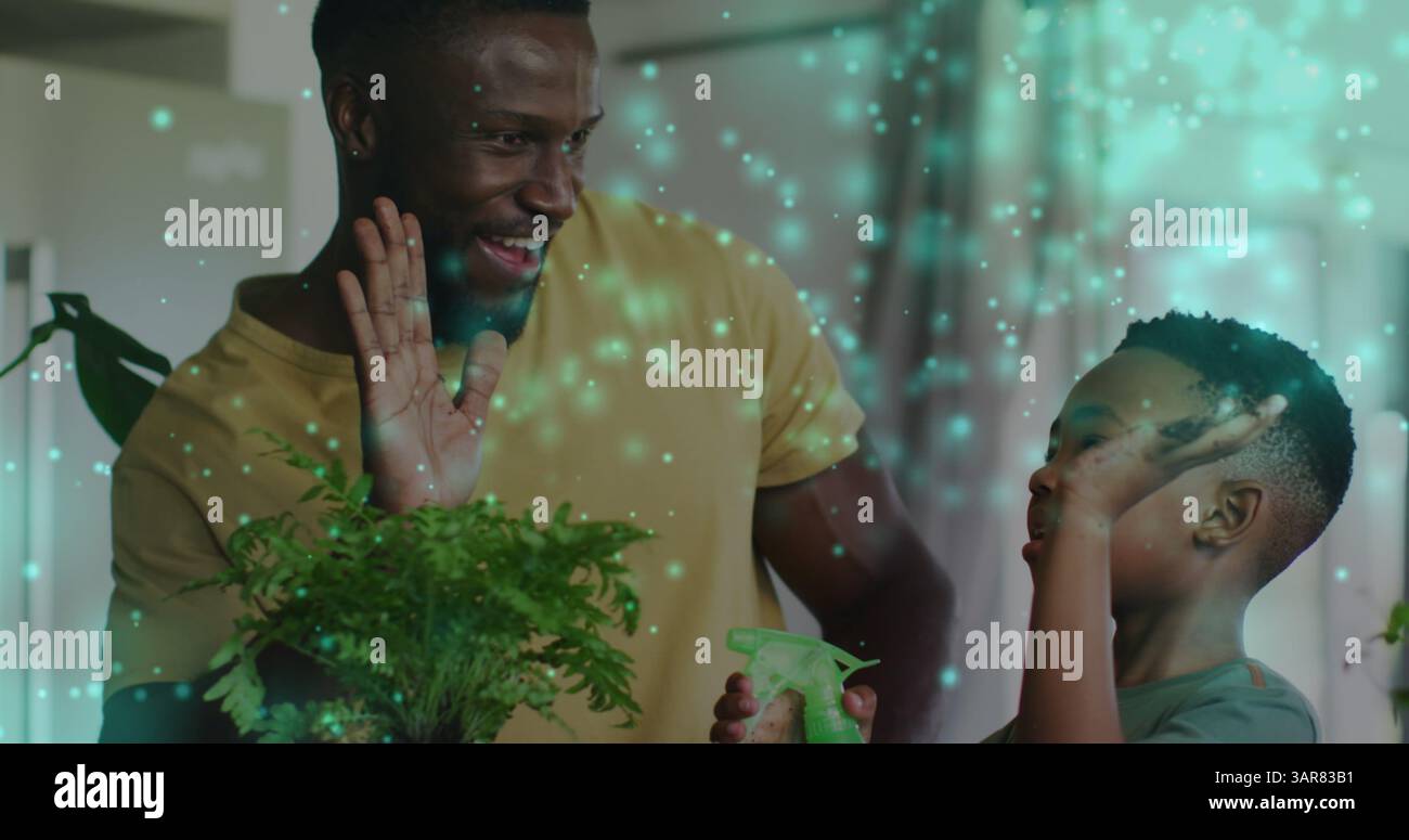 Image of lights over happy african american father and son watering ...