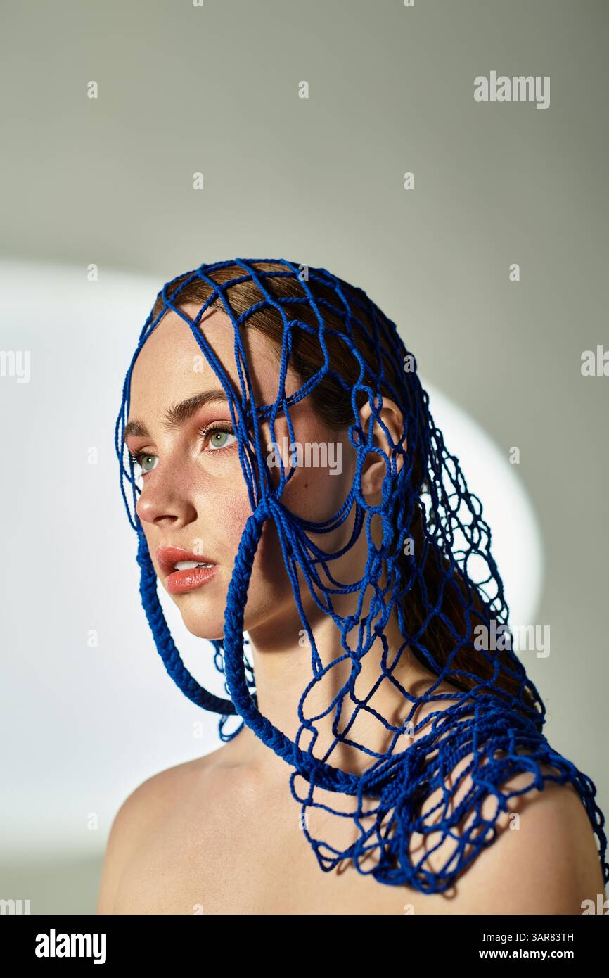 Beautiful young woman showcases an artistic look with intricate blue ...