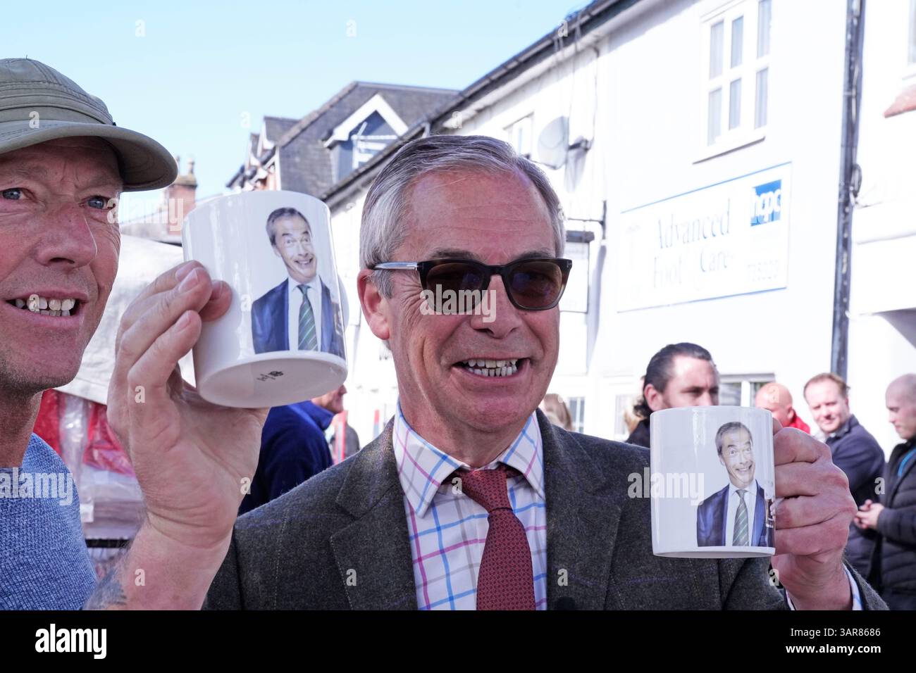 Reform UK leader Nigel Farage (right) holding a mug with his picture on ...