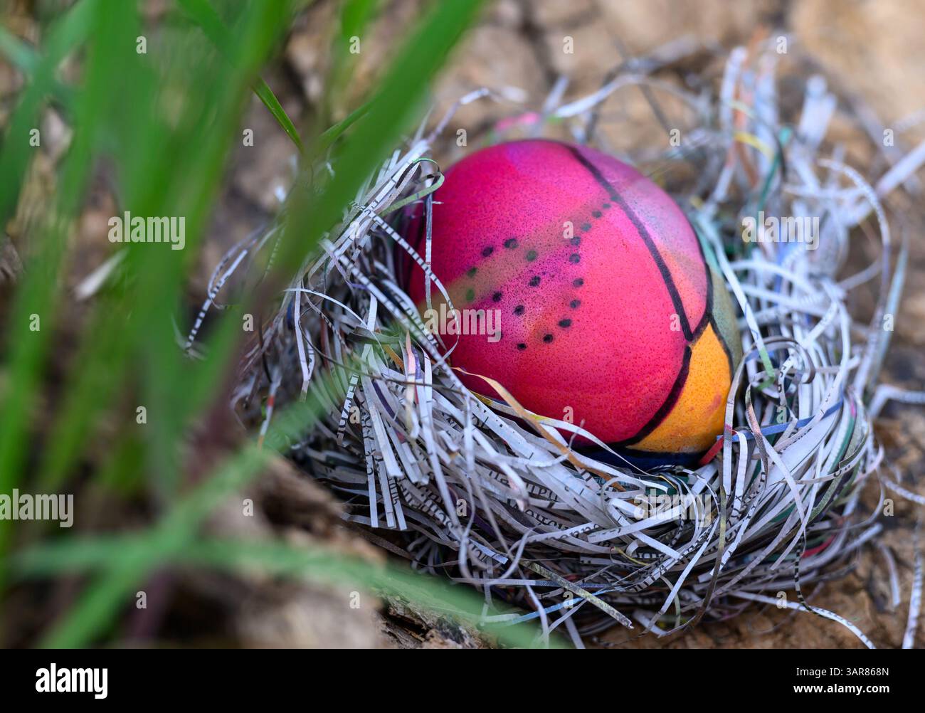 17 April 2025, Thuringia, Weimar: A colorfully painted Easter egg lies ...