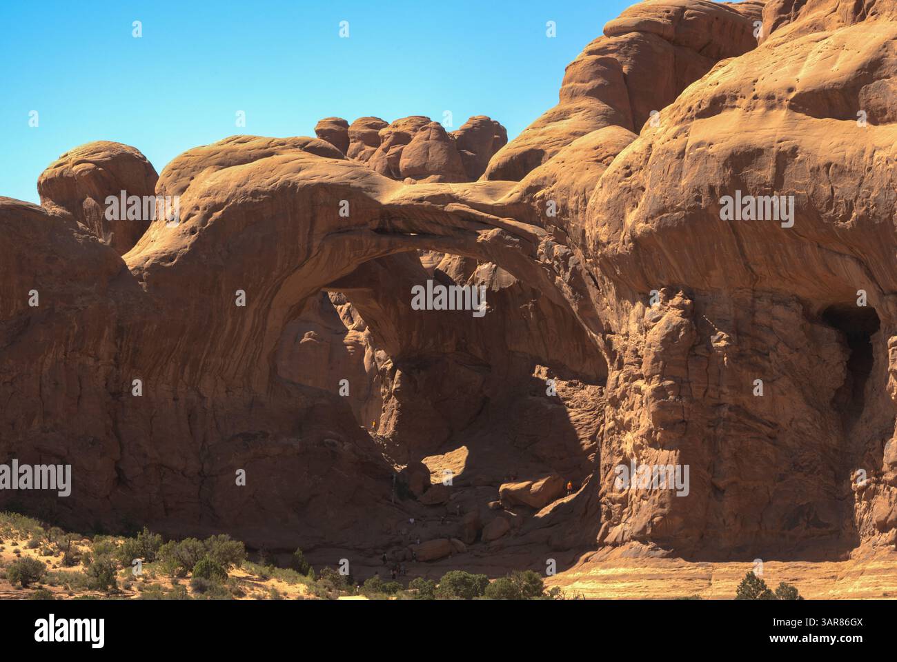A magnificent stone arch stands majestically in a rugged desert ...