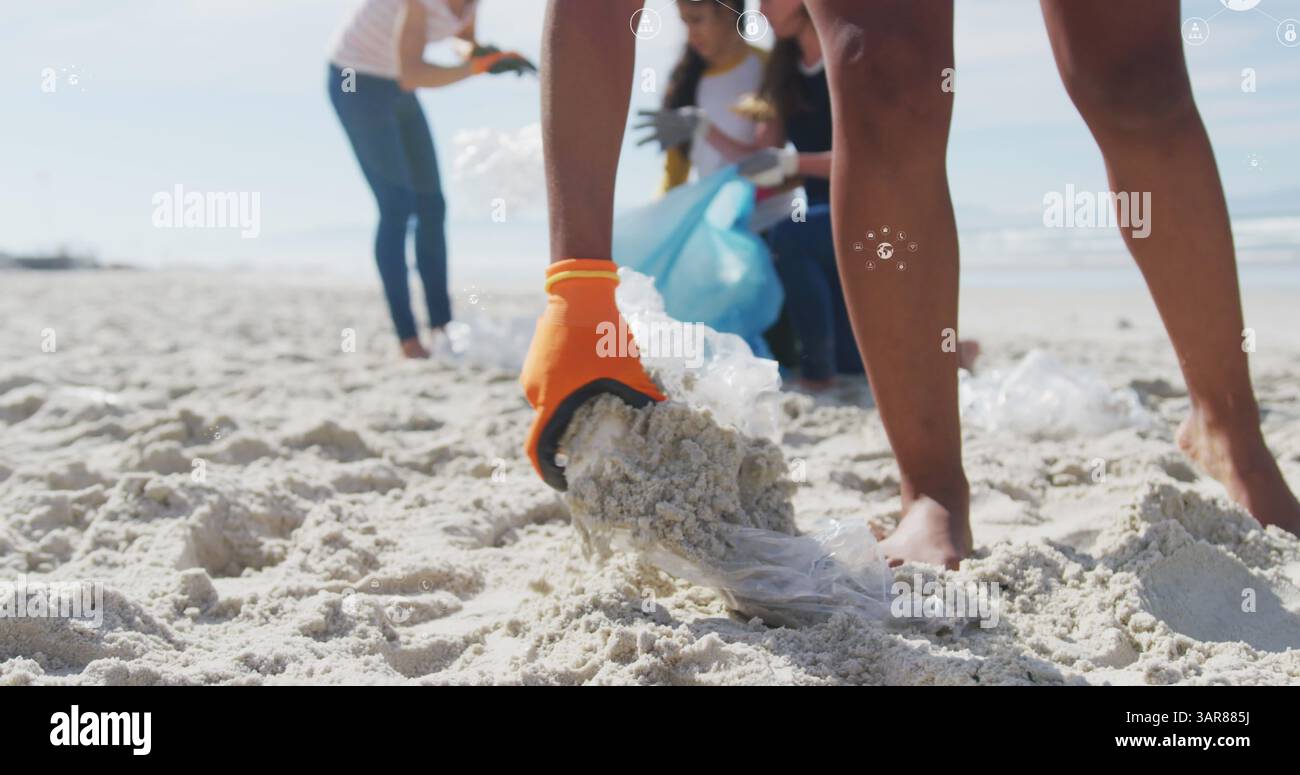 Image of globe icons over hand of biracial female volunteer picking up ...