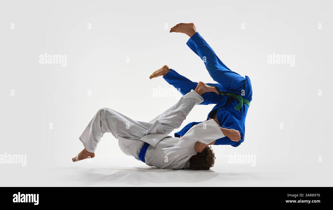 Ground-level flip from judoka in white as fighter in blue is thrown ...