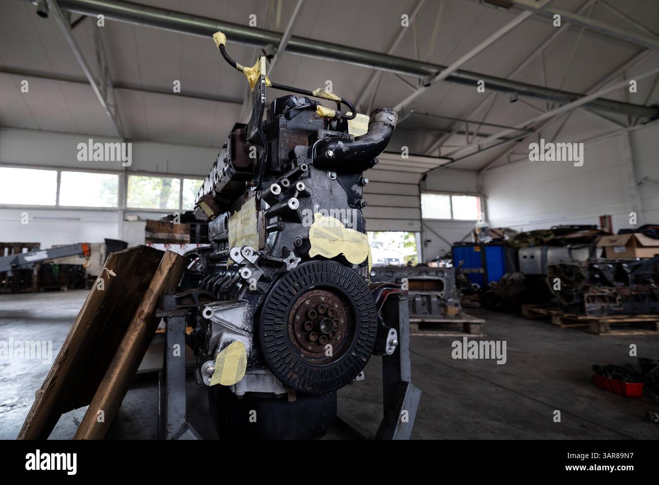 A disassembled diesel truck engine block stands in a repair shop or ...