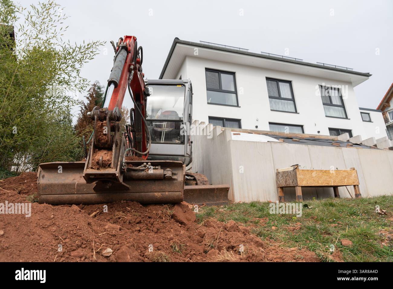 Compact Excavator Digging Soil on a Sloped Construction Site. High quality photo Stock Photo - Alamy
