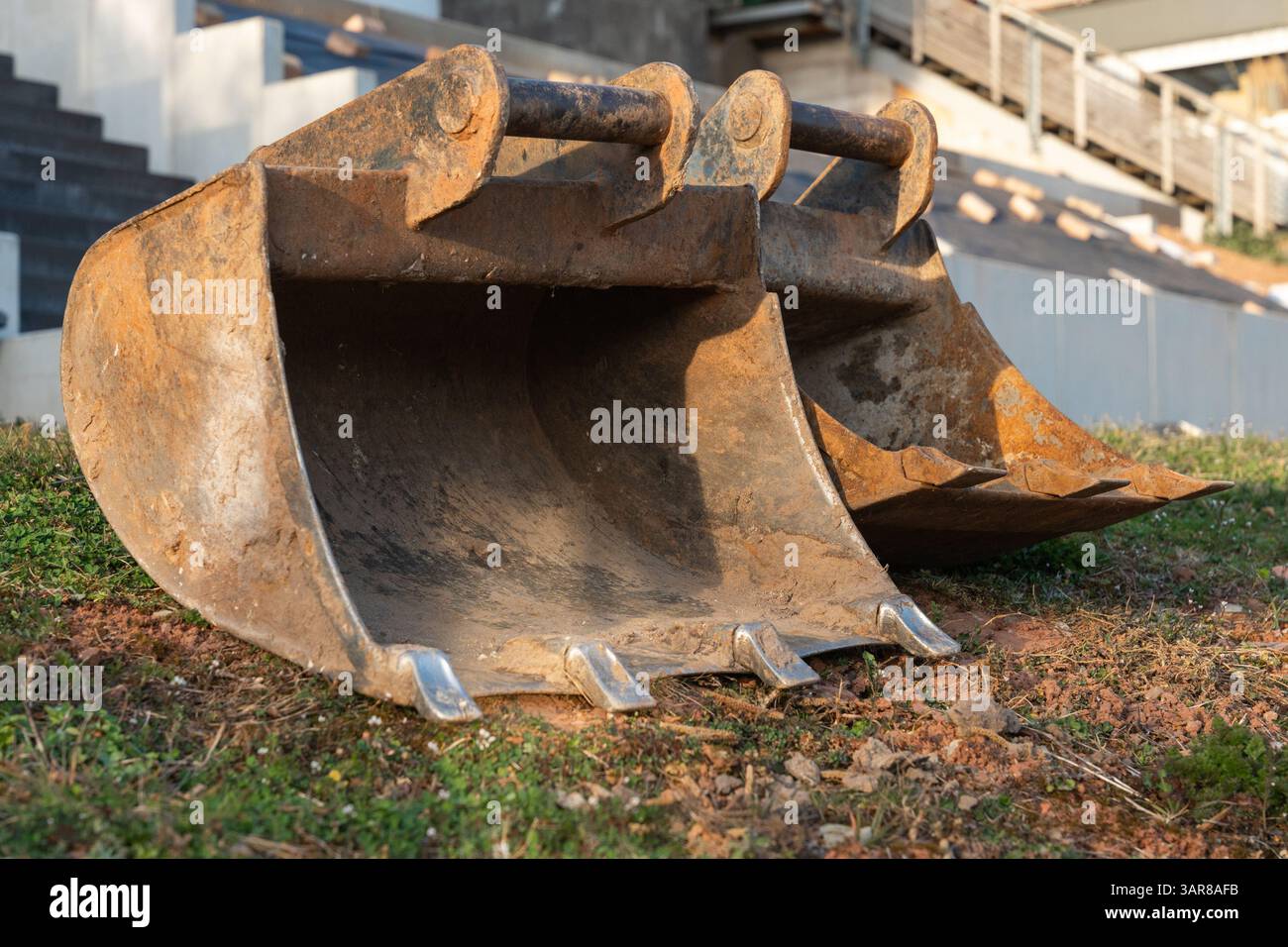 Rusty digger attachments on the ground at a home building site. Mini ...