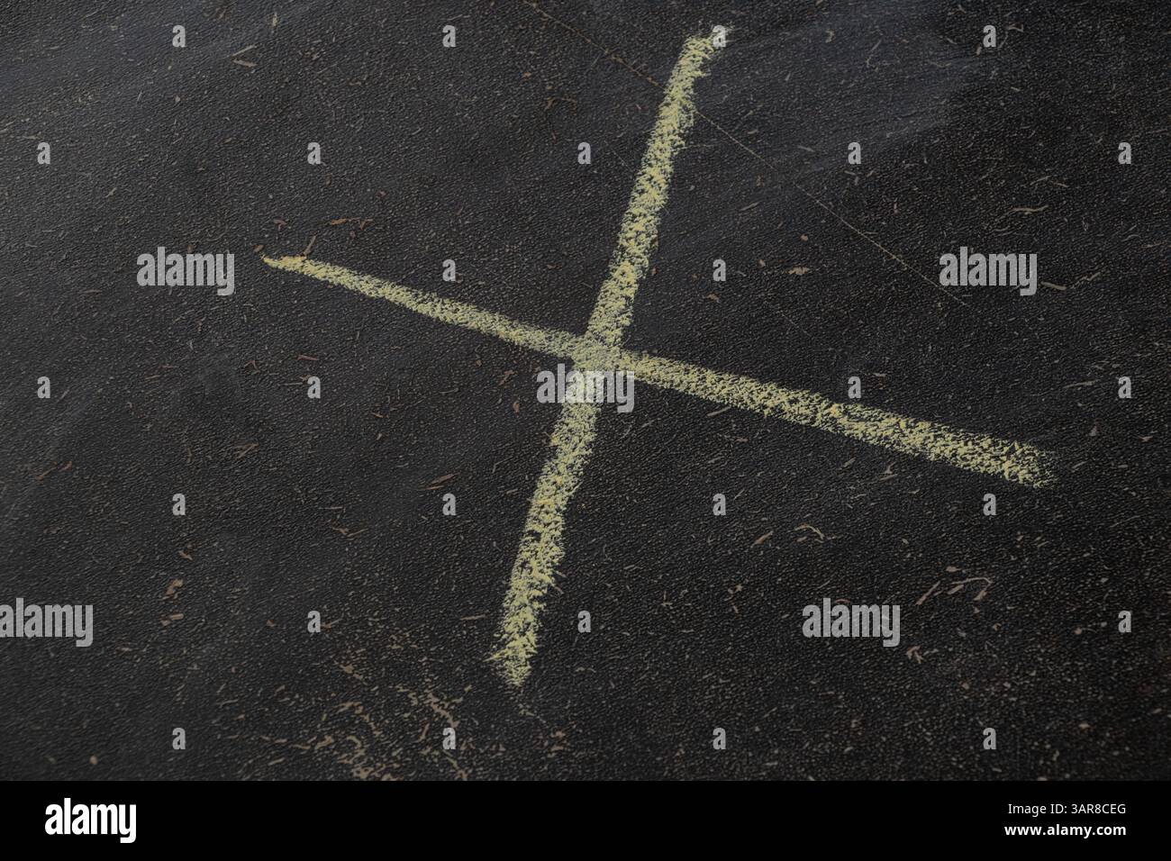 The sign of the cross is drawn on a black school board with yellow ...