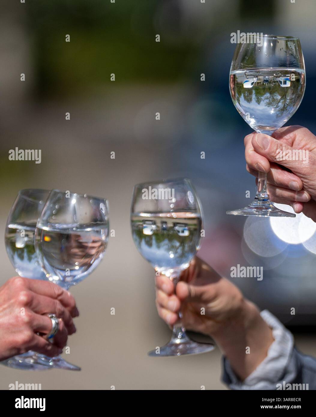 Berlin, Germany. 17th Apr, 2025. Three hands clink glasses with three ...