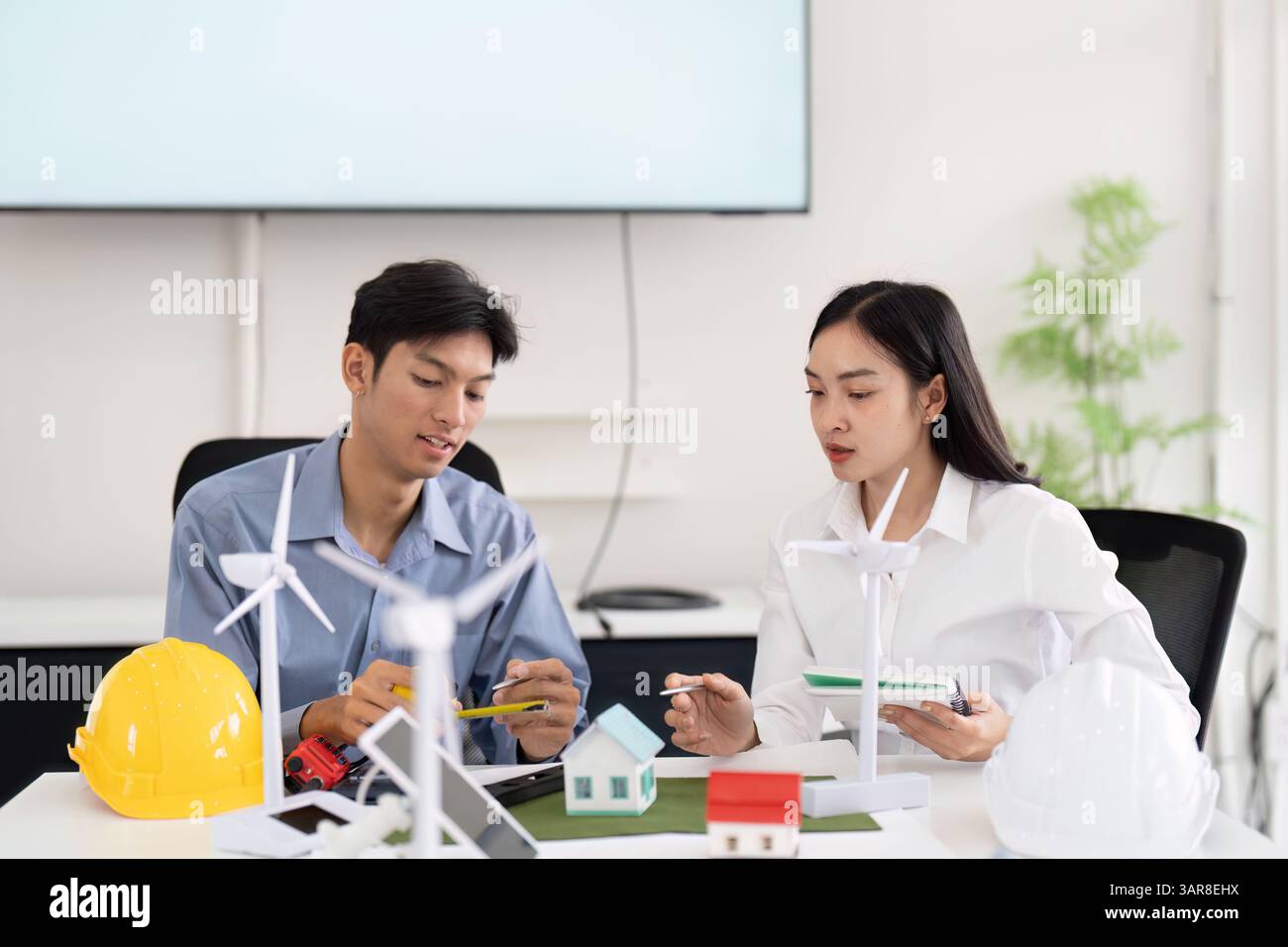 Collaboration and Eco-Friendly Engineering. Two engineers brainstorm sustainable solutions using ...