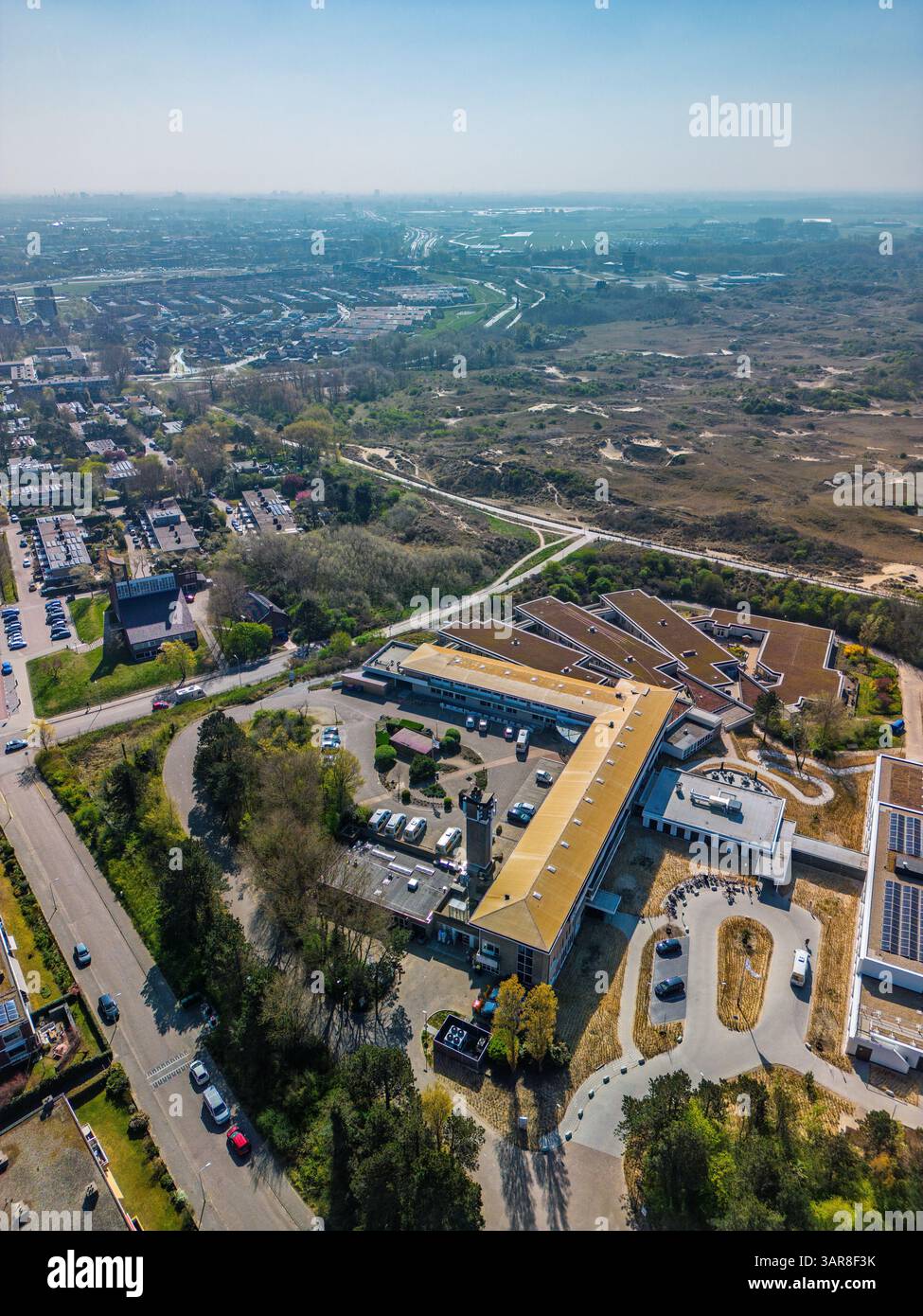 Aerial view of a modern building complex with solar panels, surrounded ...