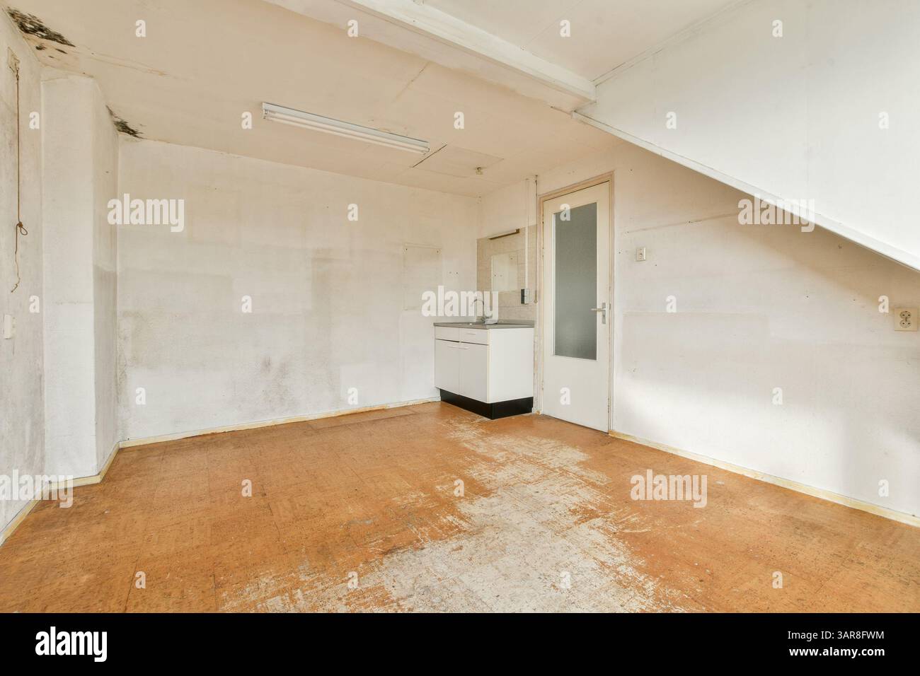 A sparsely furnished room featuring plain walls and minimal décor ...