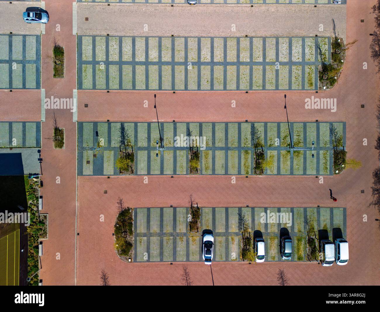 Aerial view of a nearly empty parking lot with a few parked cars, neat ...