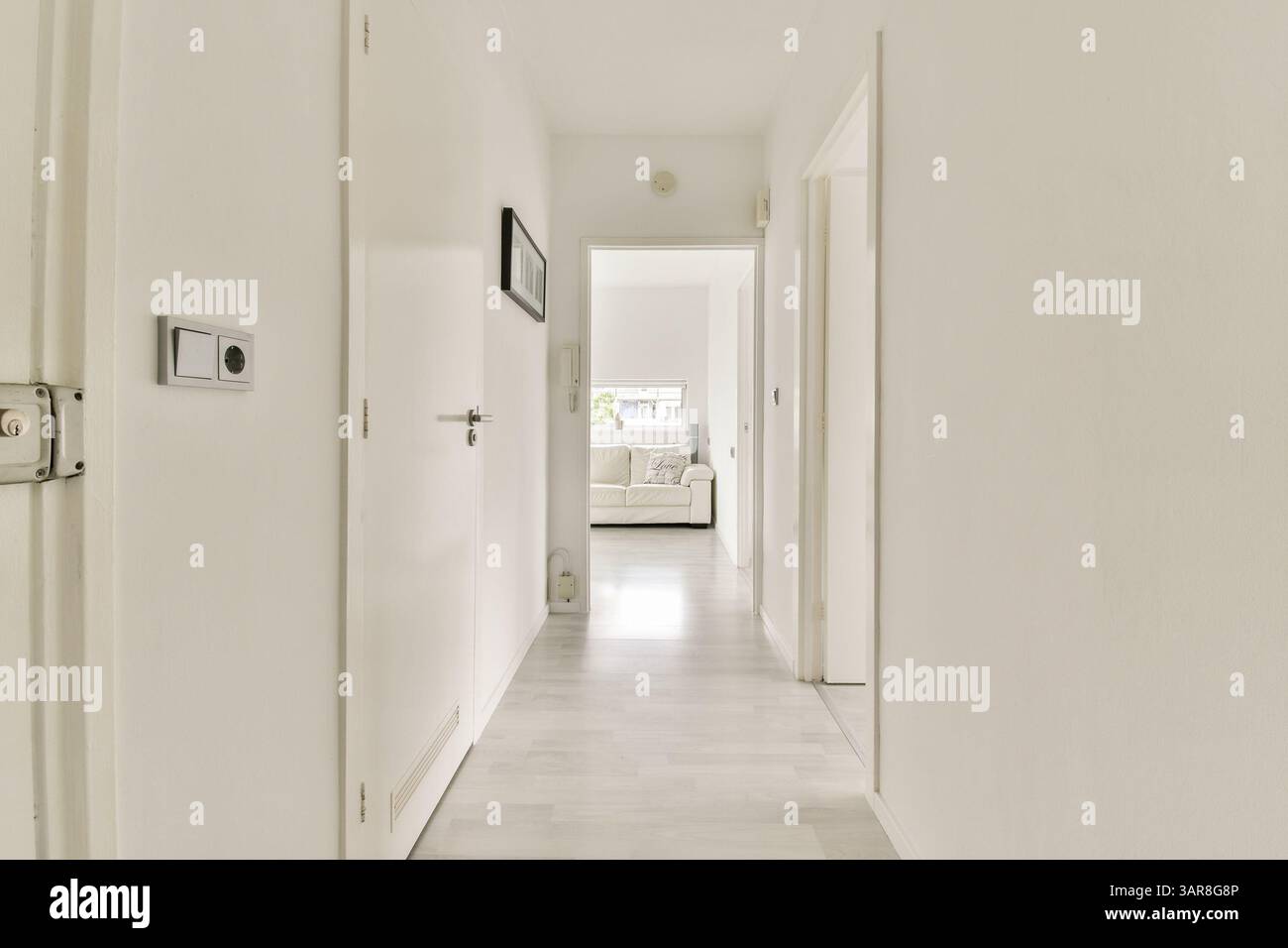 A spacious and well-lit hallway featuring clean lines and light-colored ...