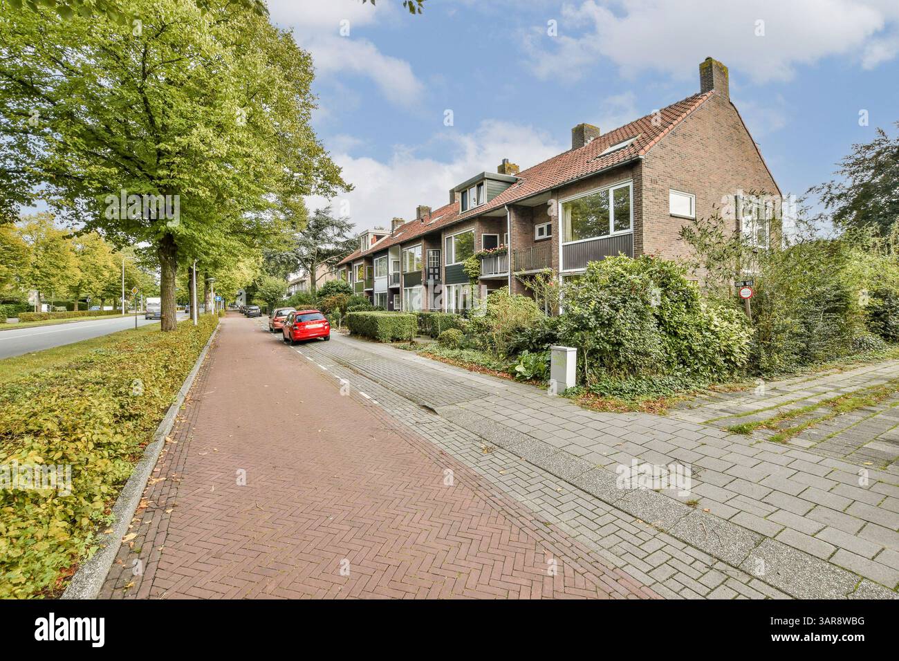 An inviting urban street scene lined with trees and residential ...