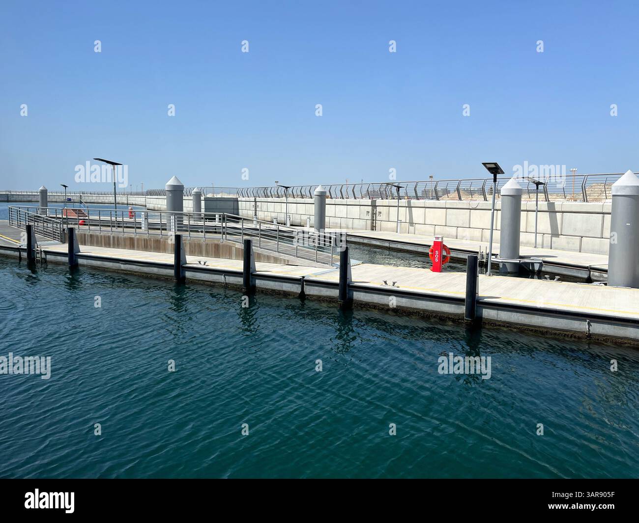 Modern floating dock in the marina with solar panels, lifebuoys in the ...
