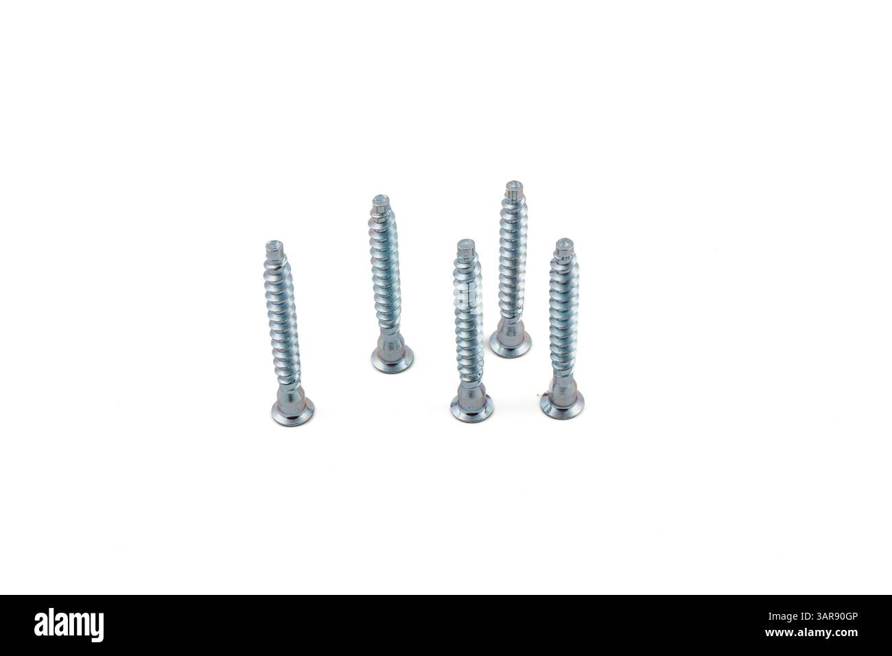 Five metallic screws with a shiny finish are displayed upright on a ...