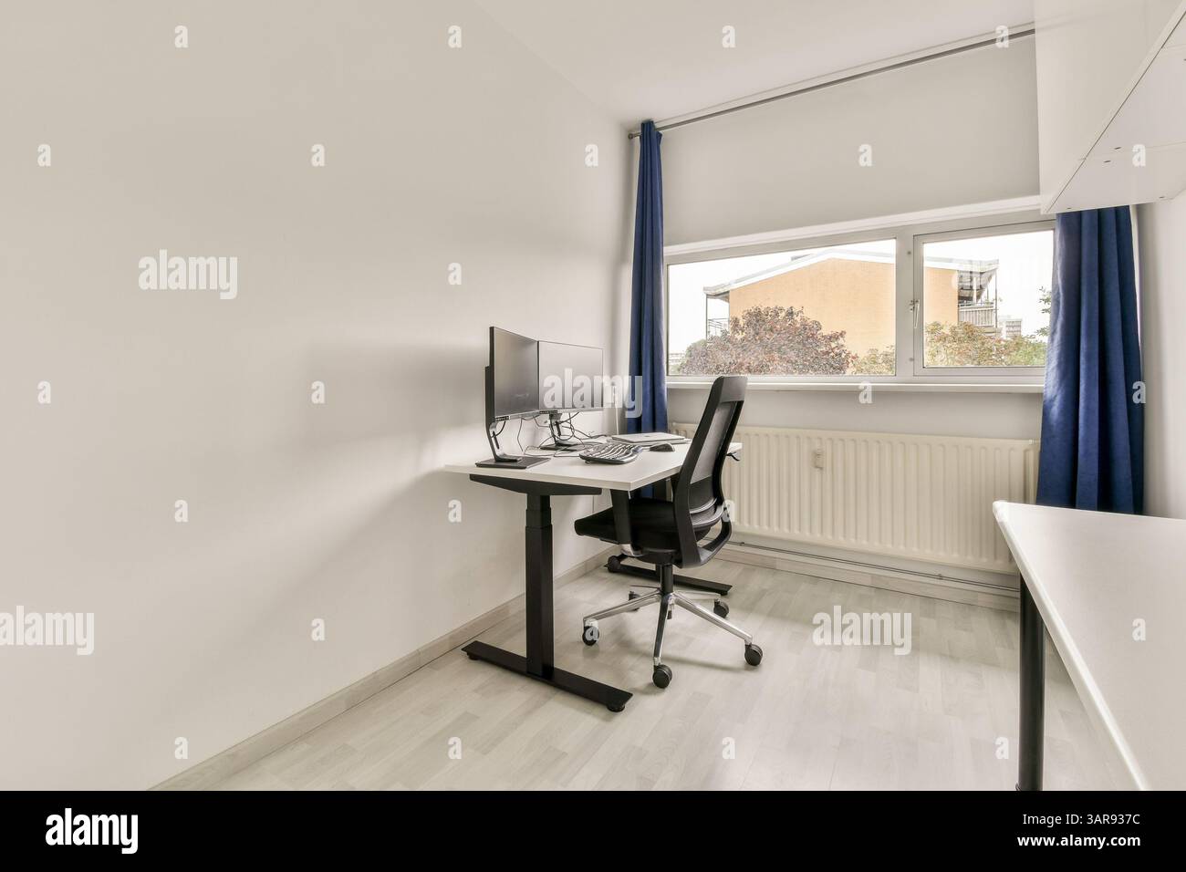 A sleek and minimalistic home office featuring a desk with a computer ...