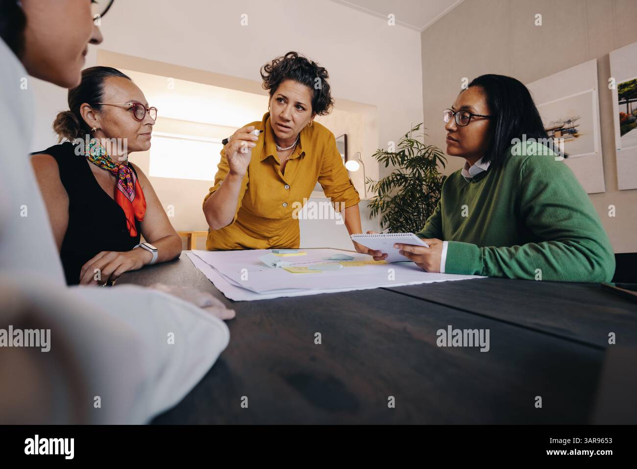 Team members gathering around meeting hi-res stock photography and ...
