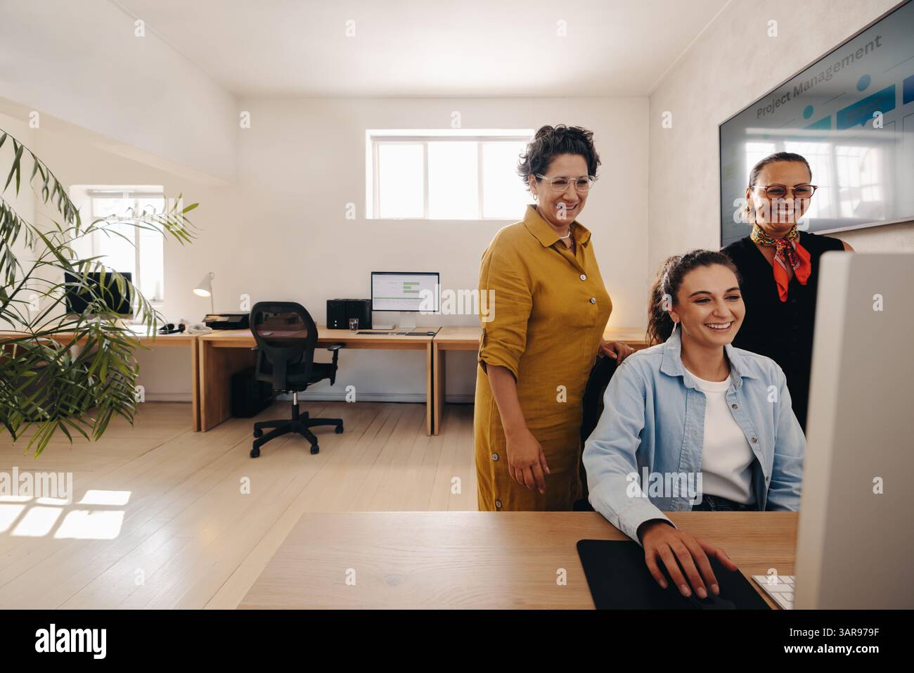A group of coworkers collaborating while examining a project scope on a ...