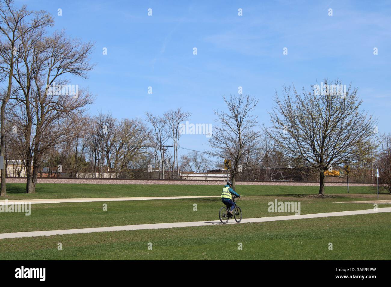 One man riding a bicycle in spring on the Des Plaines River Trail at ...