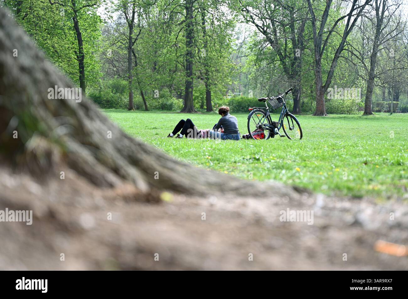 Leipzig, Germany. 17th Apr, 2025. A couple sunbathing in Clara Zetkin Park. Up to 29 degrees are ...