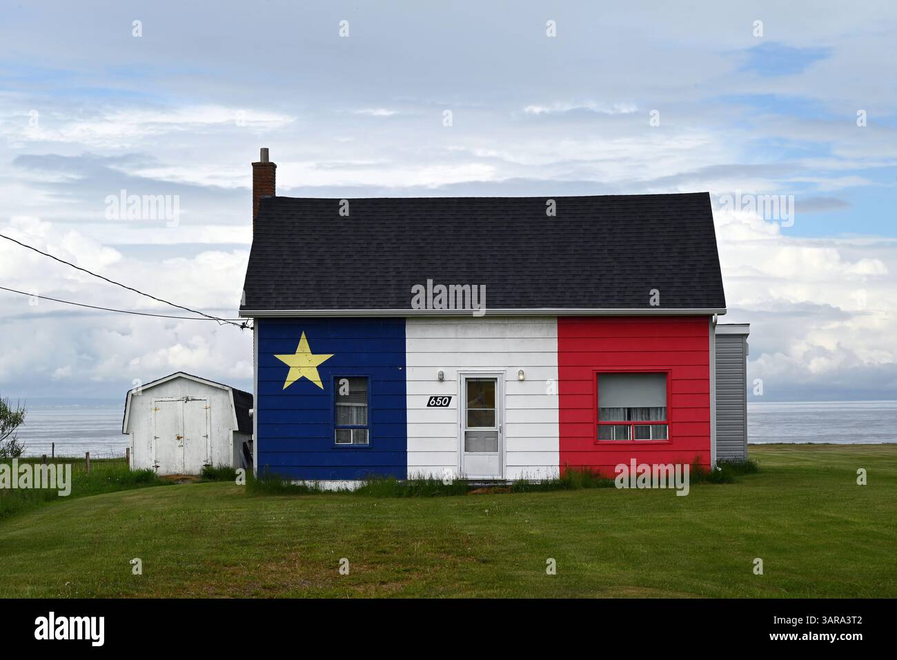 A house in Acadia fully painted with the acadian flag, french colors ...