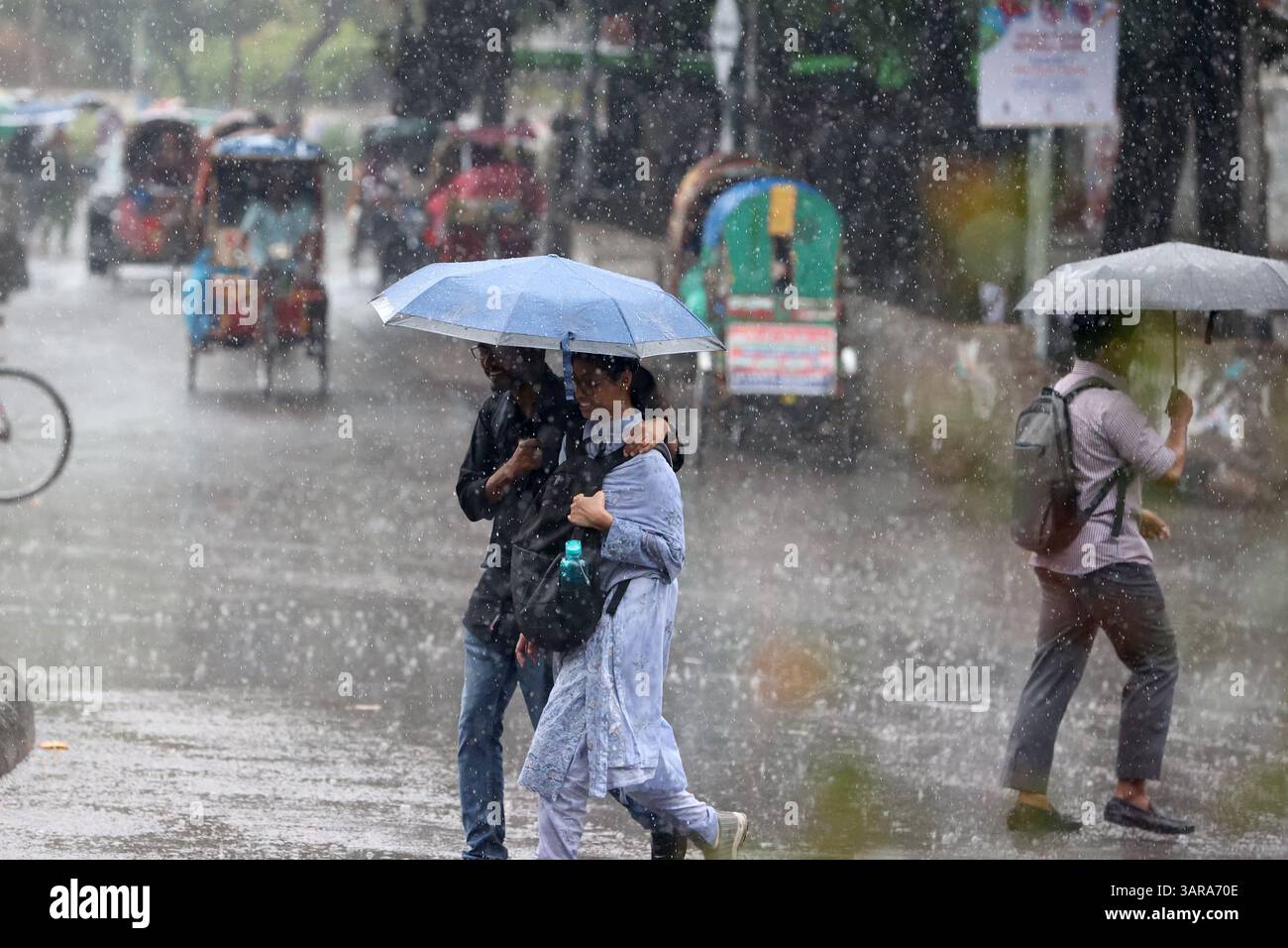 Dhaka, Bangladesh - April 17, 2025: Vehicles try to drive through an off-season rain shower ...