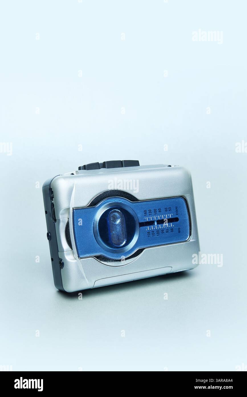 Silver and blue personal cassette player against light blue background ...