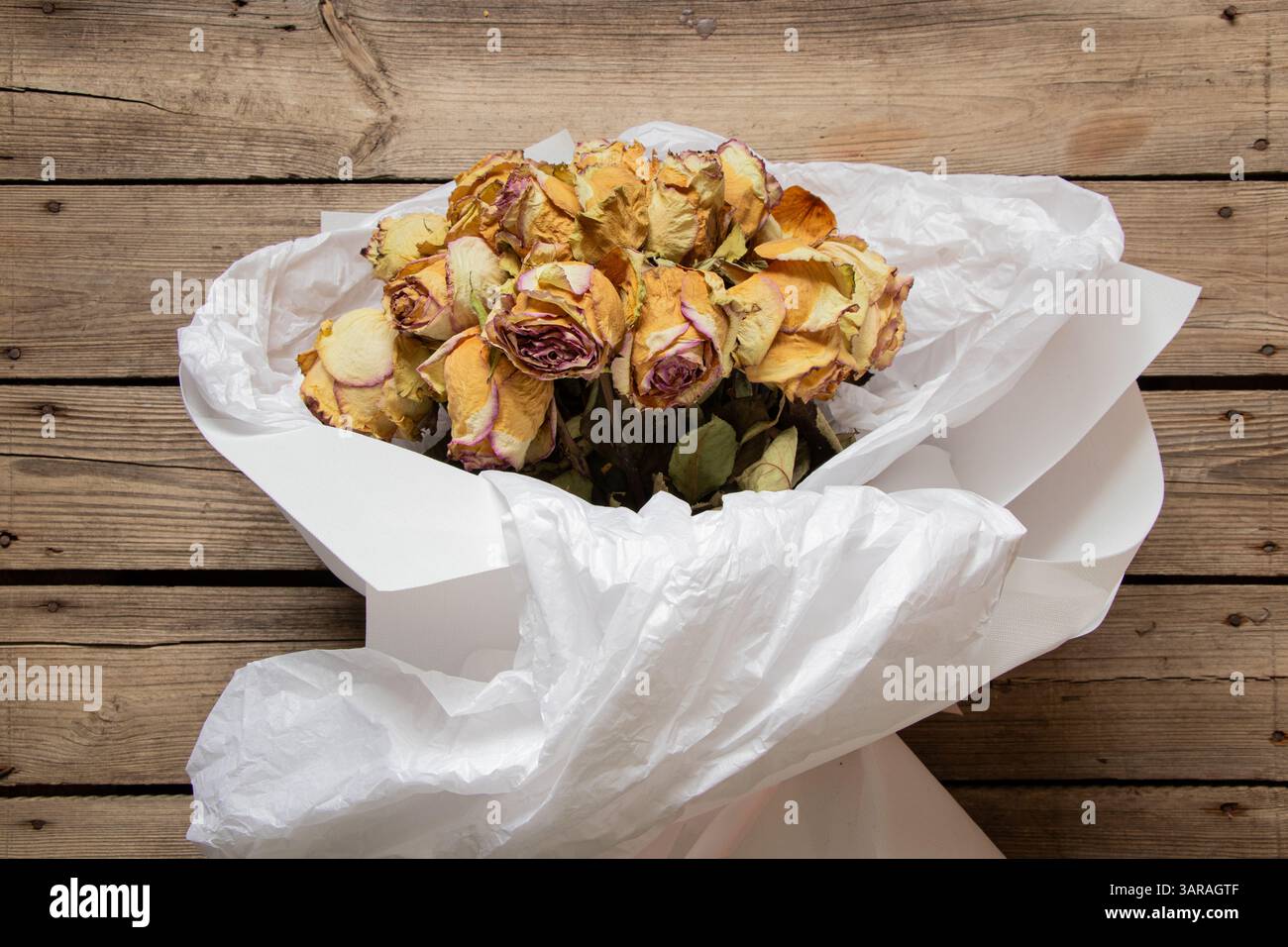 Large bouquet with roses and white wrapping on the table in ...