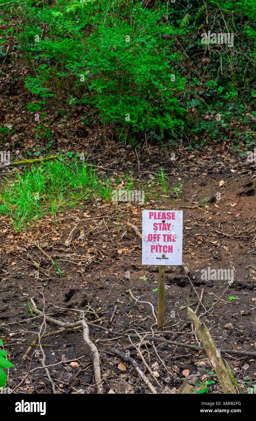 White sign with 'Please stay of the pitch' in the middle of a swamp ...